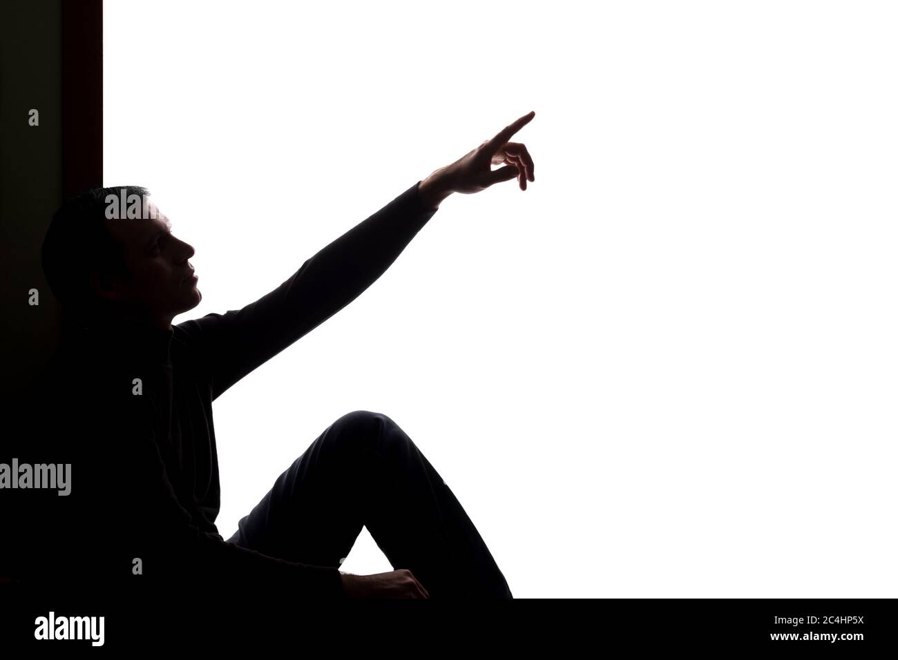 Young man sitting shows his index finger forward - silhouette Stock ...