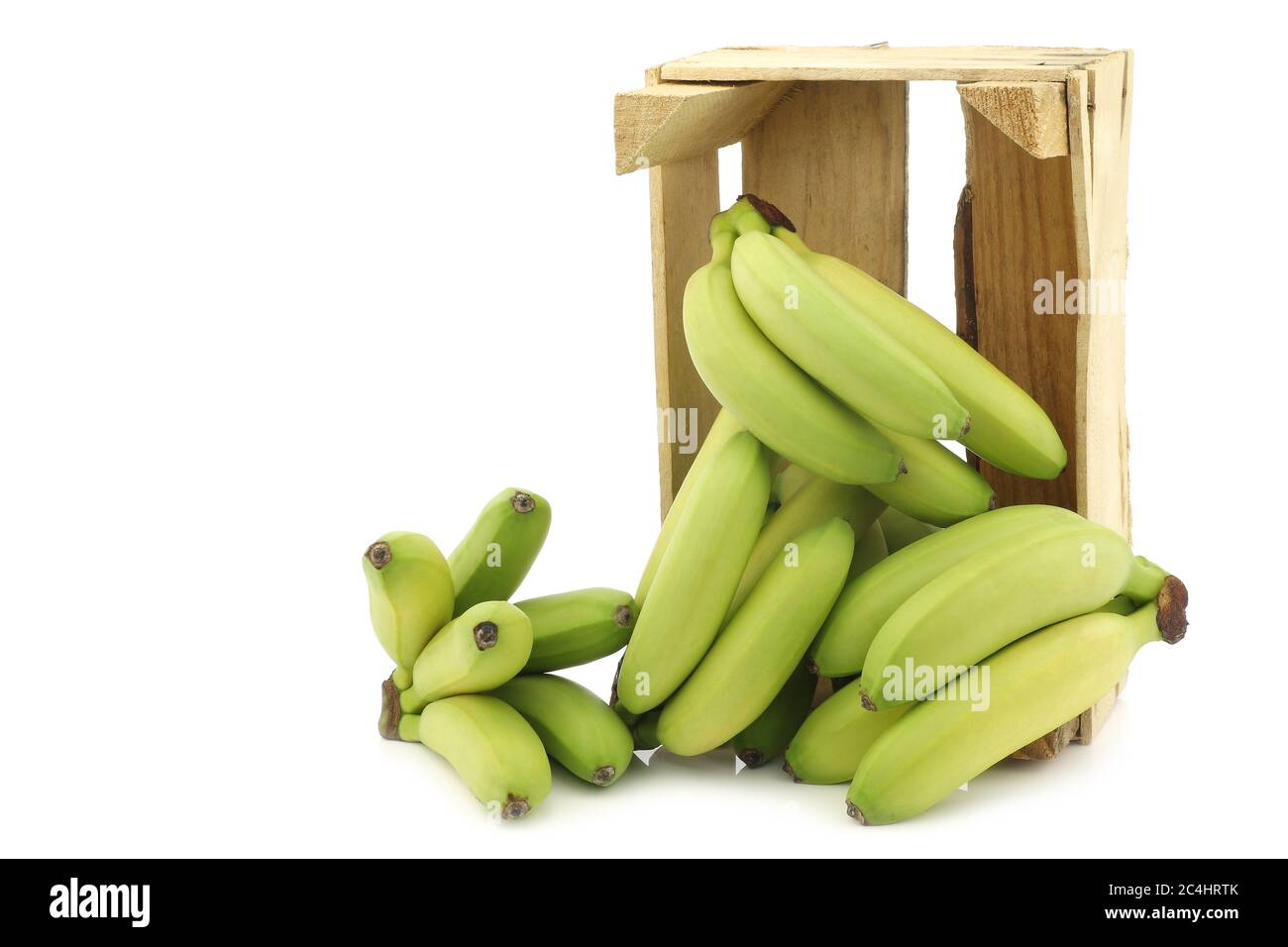 small green snack bananas in a wooden crate on a white background Stock ...