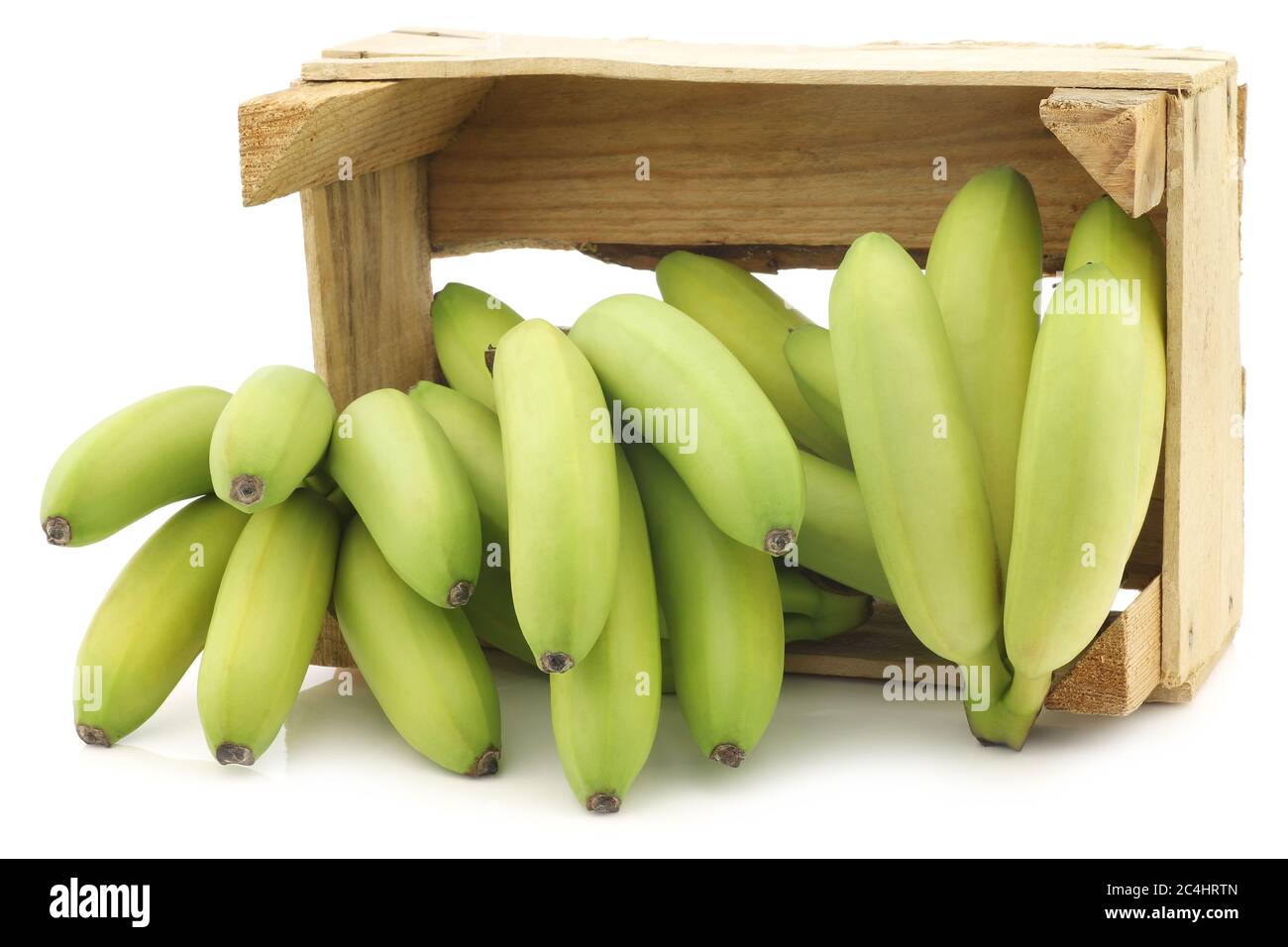 small green snack bananas in a wooden crate on a white background Stock ...