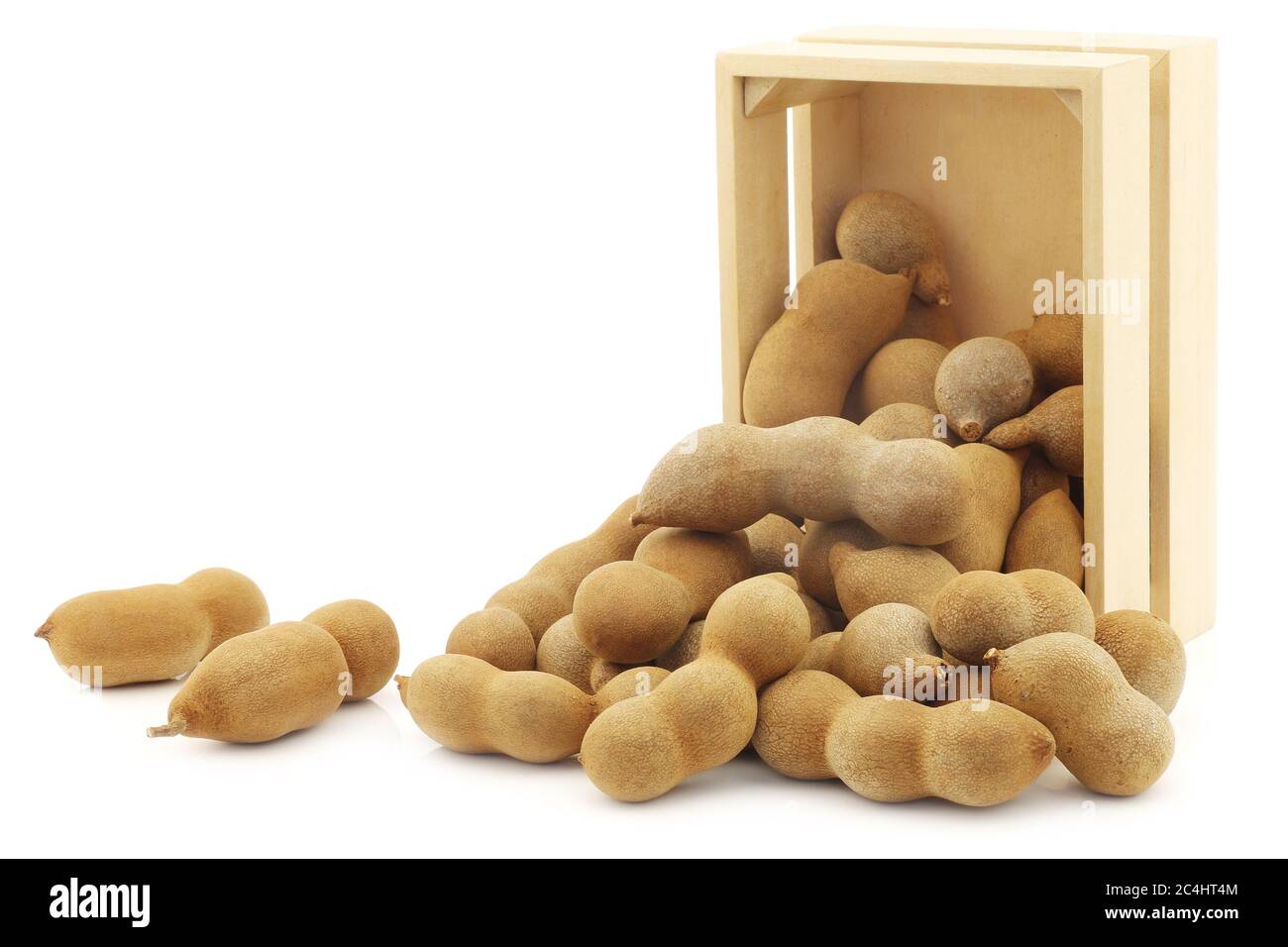 Tamarind beans in a wooden box on a white background Stock Photo - Alamy