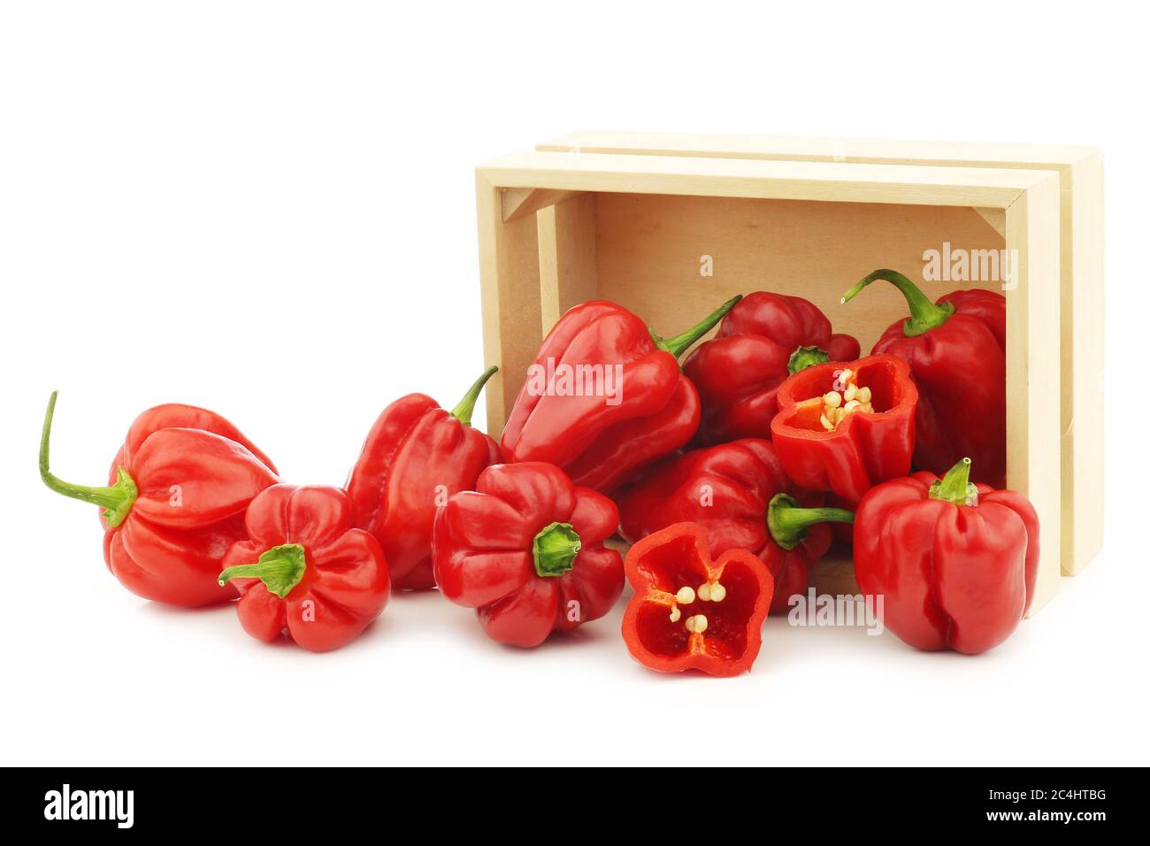 spicy hot red adjuma peppers in a wooden box on a white background ...