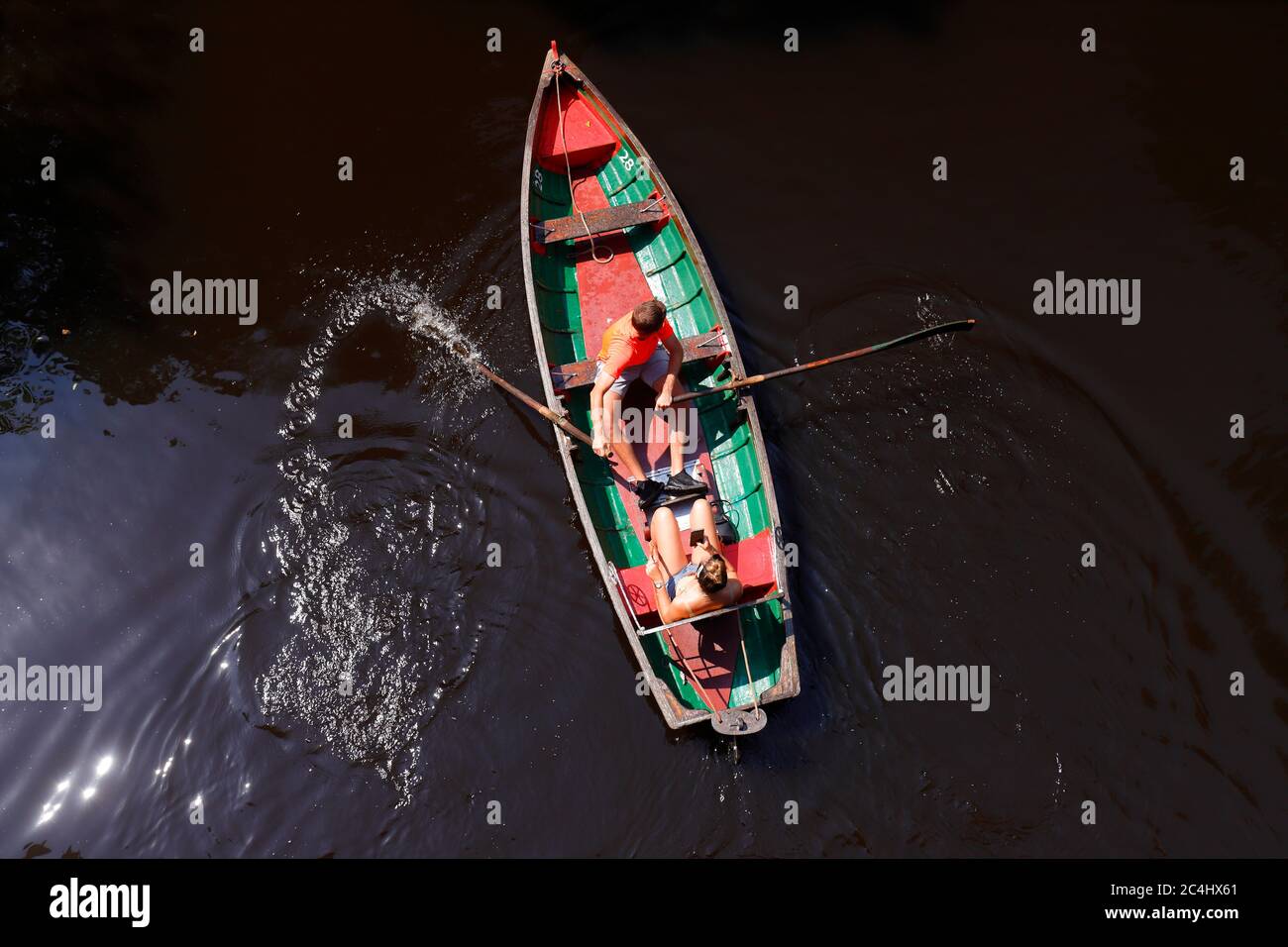 Looking down onto a man and woman rowing a boat along the River Nidd in ...