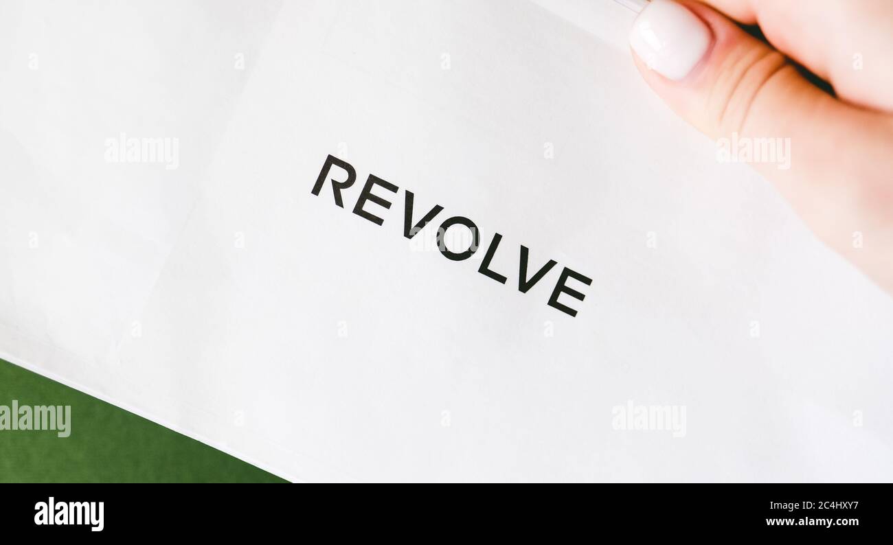 hands holding Revolve logo on green background Stock Photo - Alamy