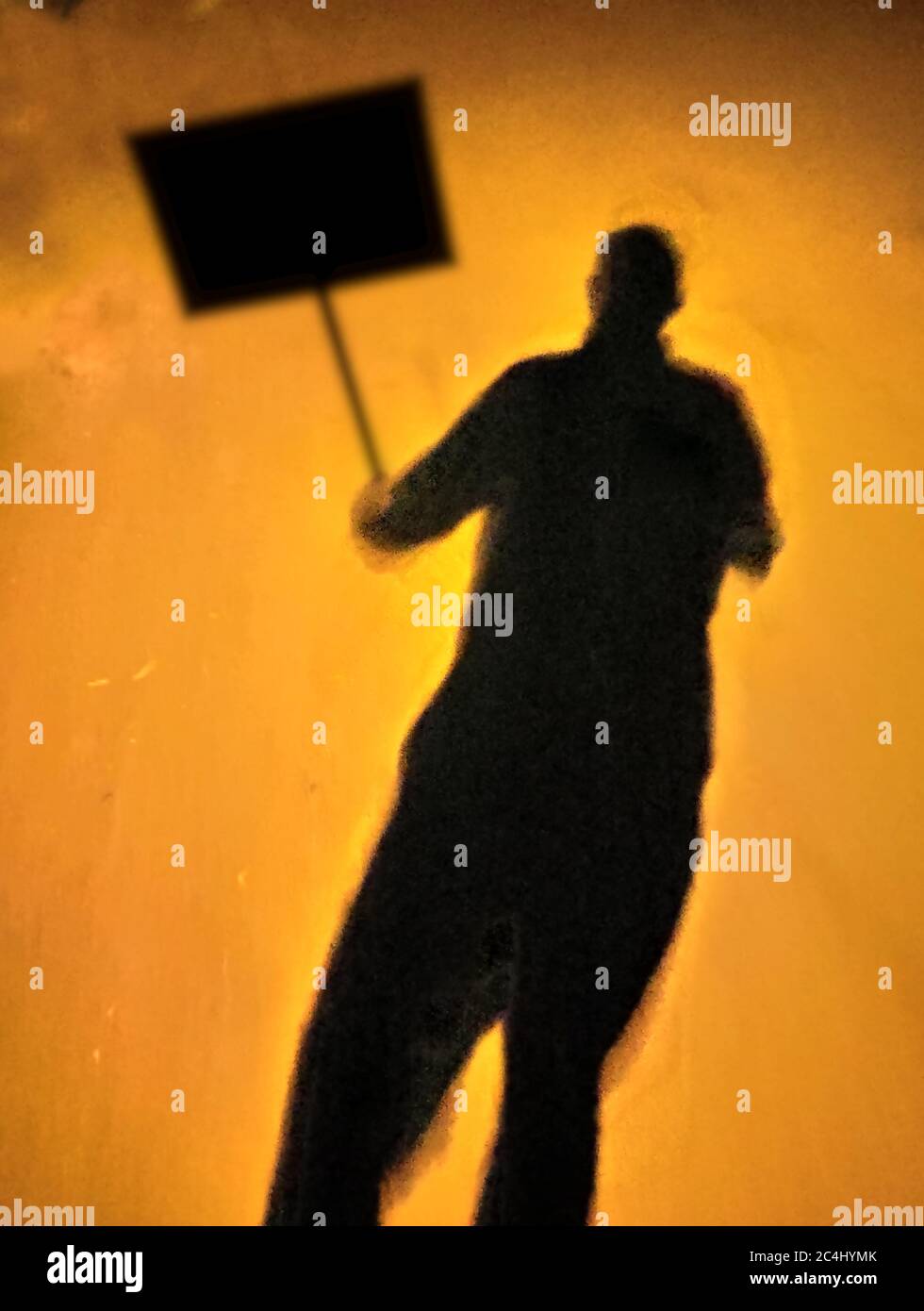 Gritty shadow or silhouette of a protestor walking on the street at ...
