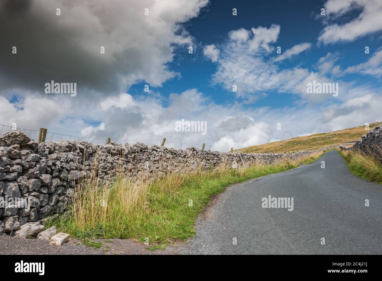 Low level view of a rural asphalt road, appearing deserted ascending a ...