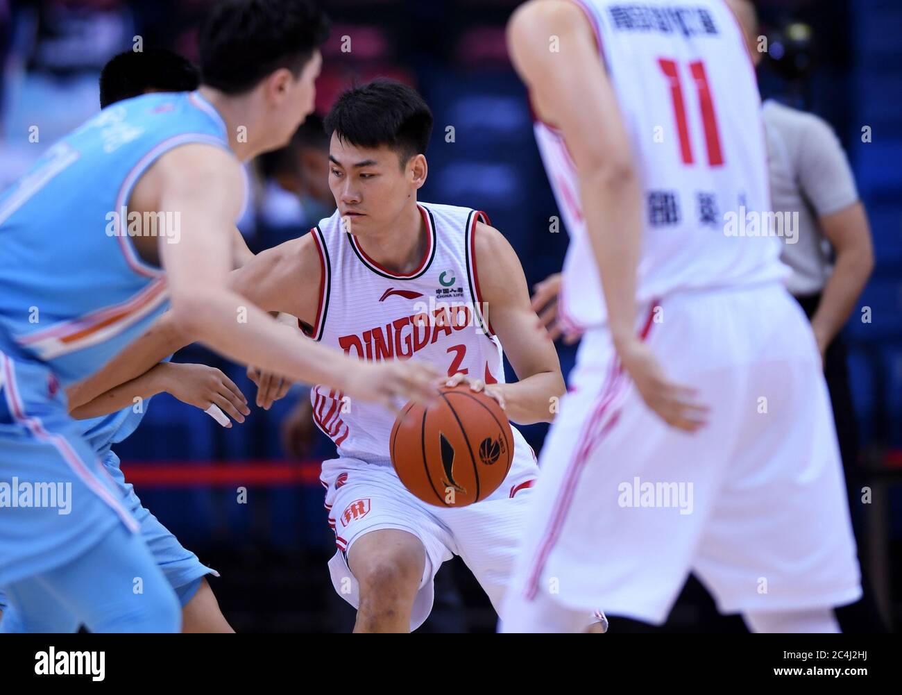 Qingdao, China's Shandong Province. 27th June, 2020. Wang Ruize (C) of Qingdao Eagles, tries to ...