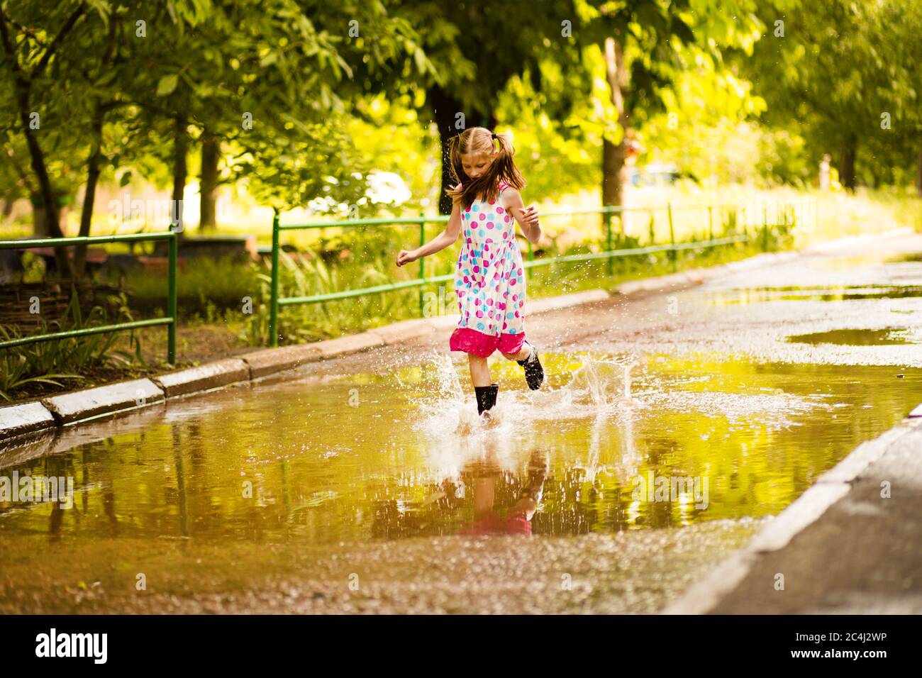 Little kid girl runs through a puddle. summer outdoor Stock Photo - Alamy