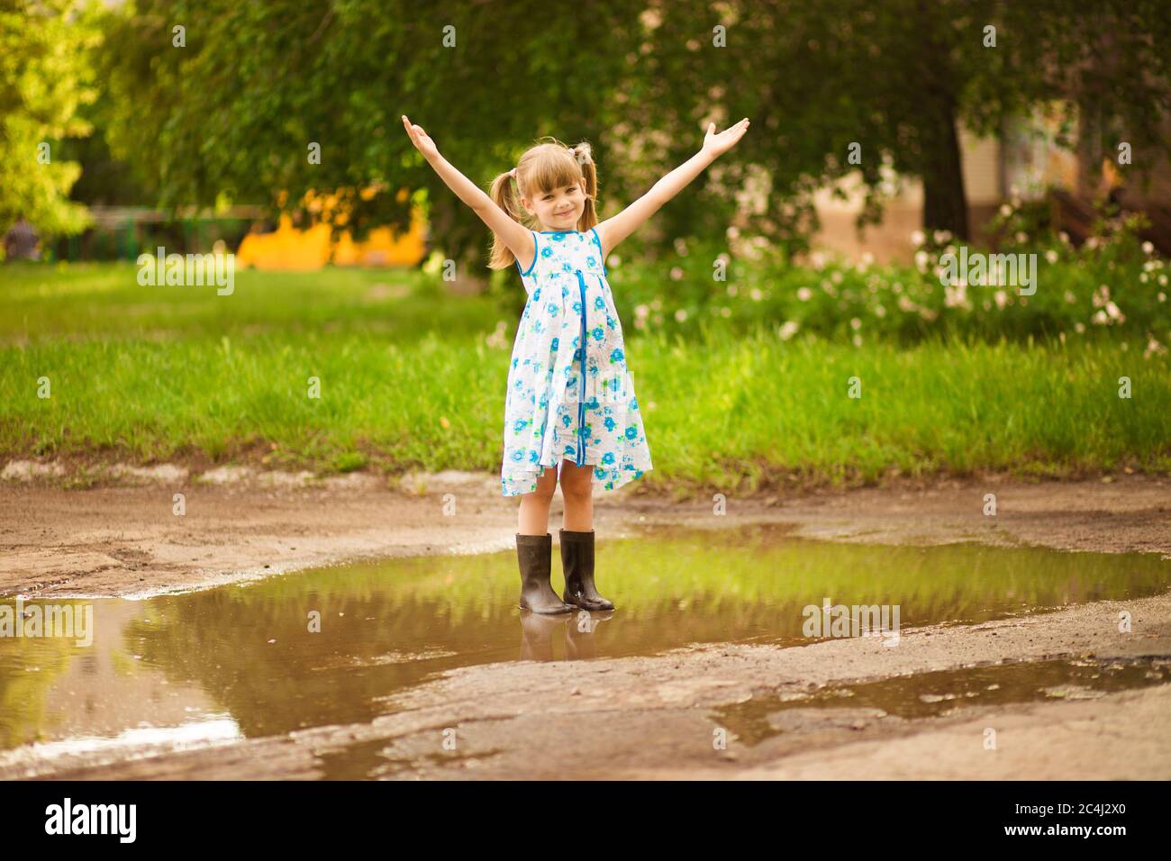 Little kid girl runs through a puddle. summer outdoor Stock Photo - Alamy