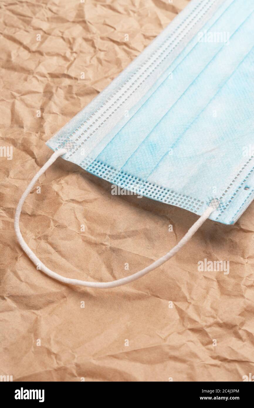 Medical protective disposable mask on crumpled paper brown background ...