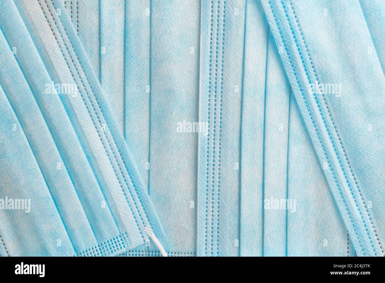 Abstract background of stacked medical blue surgical masks. Breathing ...