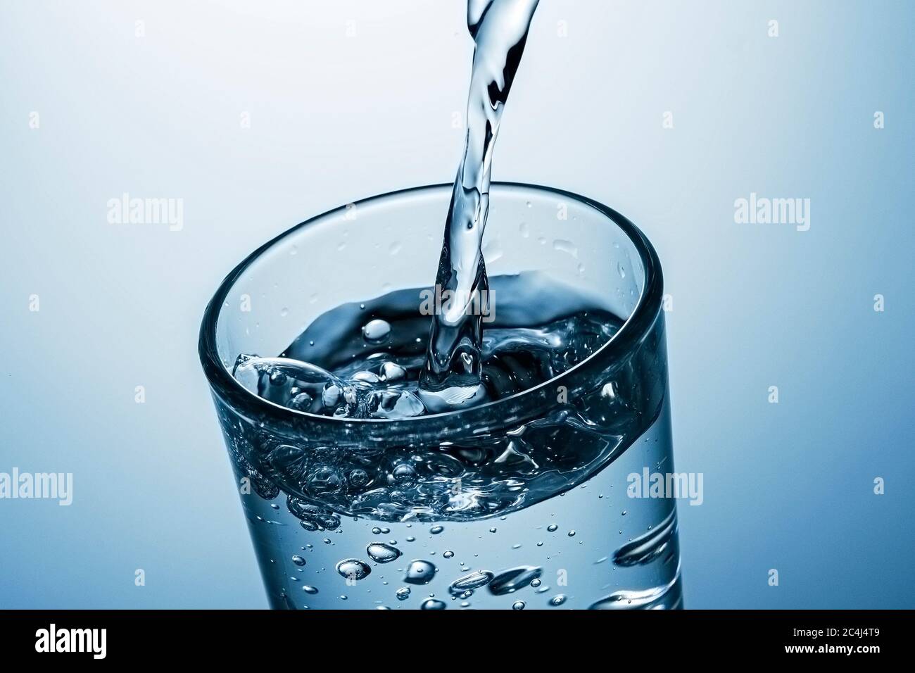 Pouring a tall glass of sparkling water with splash and effervescent ...