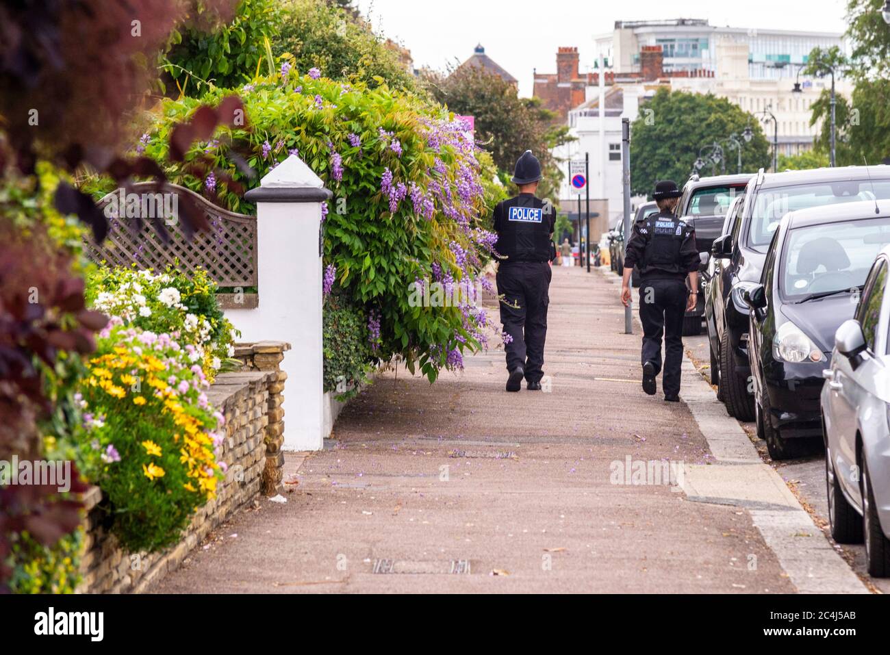 Male and female special constable police officers walking the beat in ...