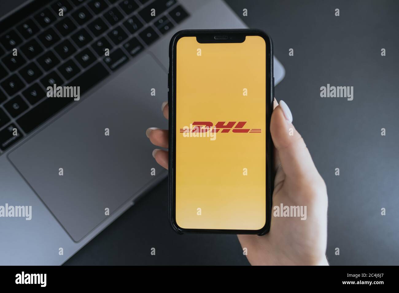 Hand holding iPhone X with DHL logo on the screen Stock Photo - Alamy