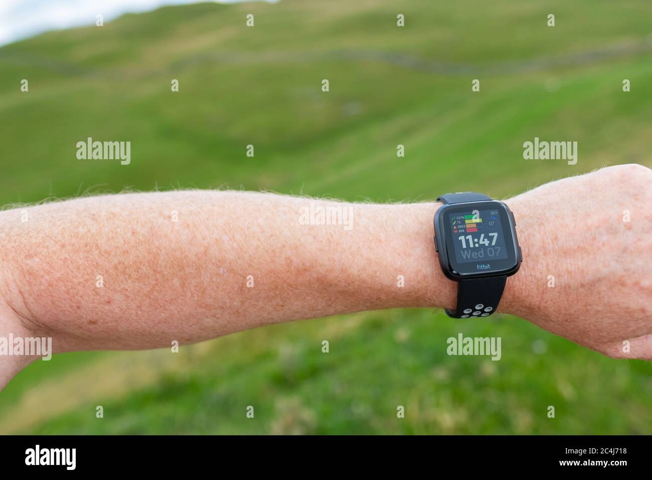 Adult male seen wearing a popular fitness tracker on his left wrist ...