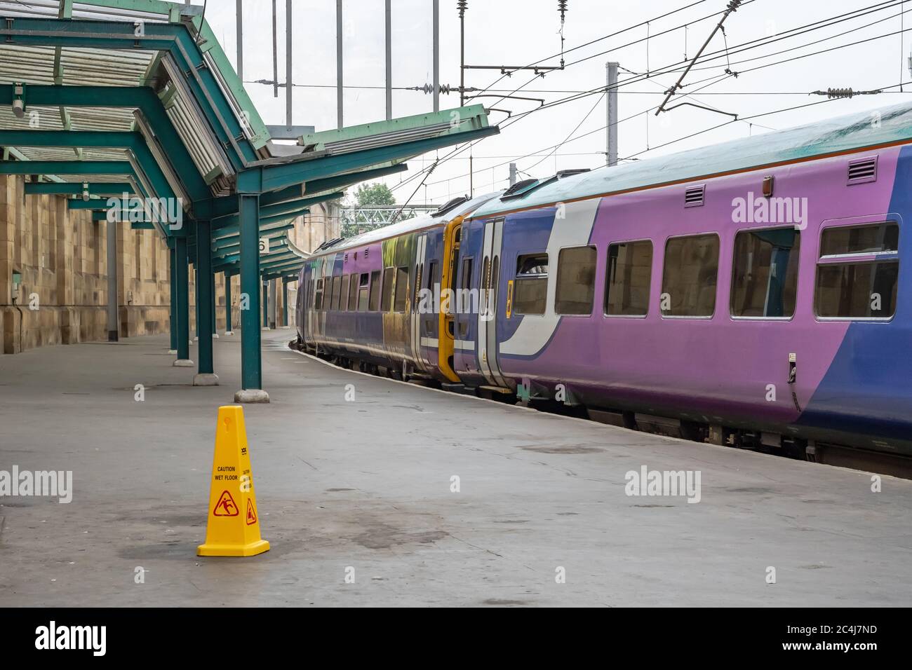 Empty main-line railway station platform, showing a yellow, slippery ...