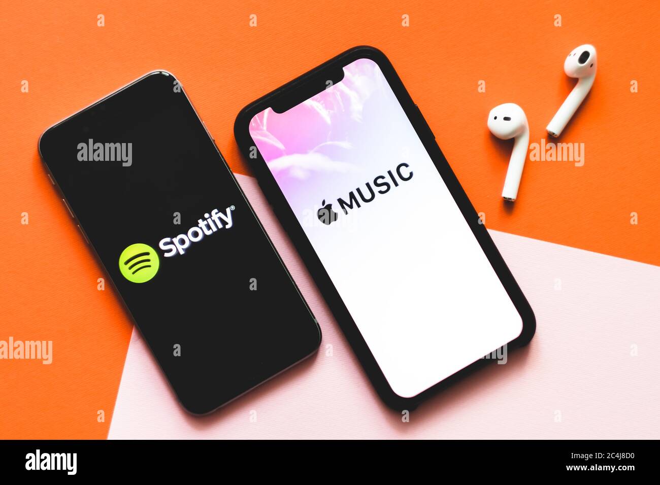 hands holding iPhone X with Screen shot of Apple music app and Spotify ...