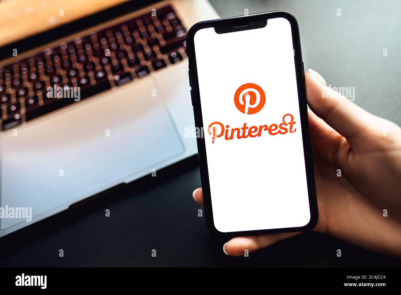 Hands holding the iPhone X with Pinterest app logo on the screen Stock ...