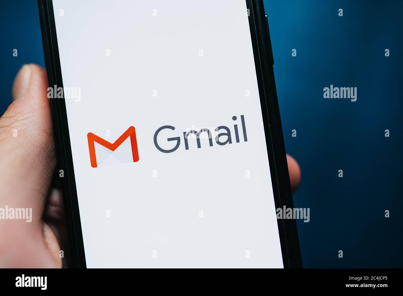 Hand holding iPhone with Gmail app logo on the screen Stock Photo - Alamy