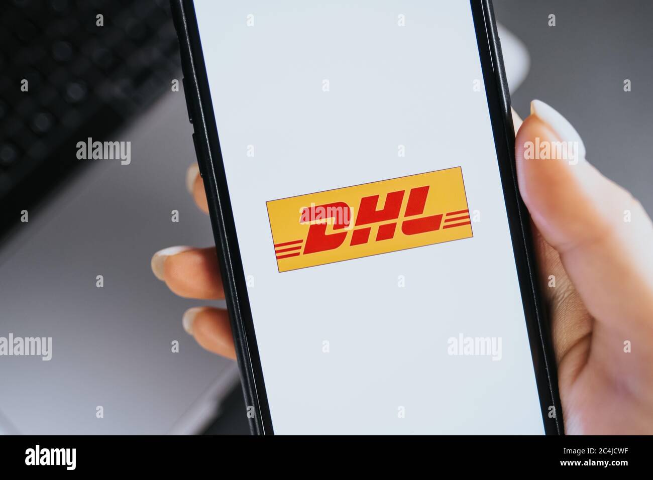 Hand holding iPhone X with DHL logo on the screen Stock Photo - Alamy