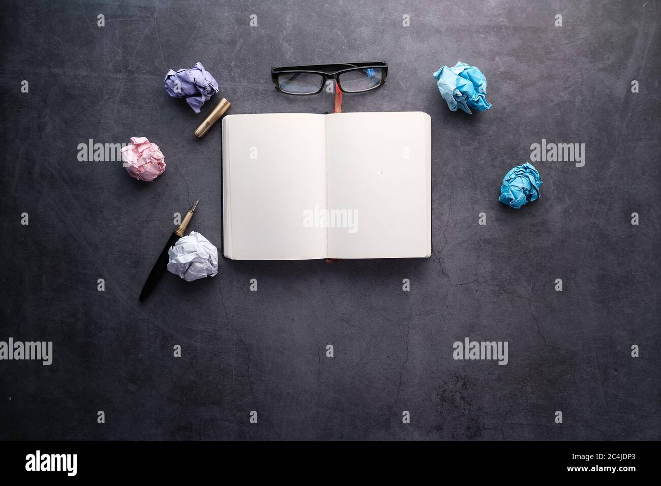 Journalist's table with notebook, crumpled paper on black background ...