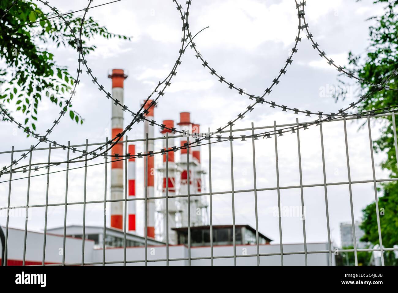 Industrial factory pipe and fence with barbed wire Stock Photo - Alamy