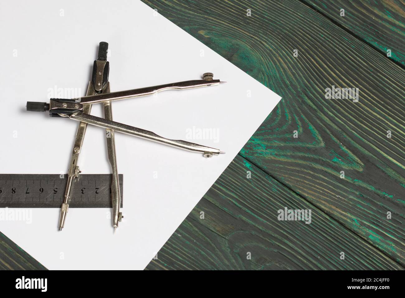Set for drawing. Two compasses, a metal ruler and a sheet of white ...