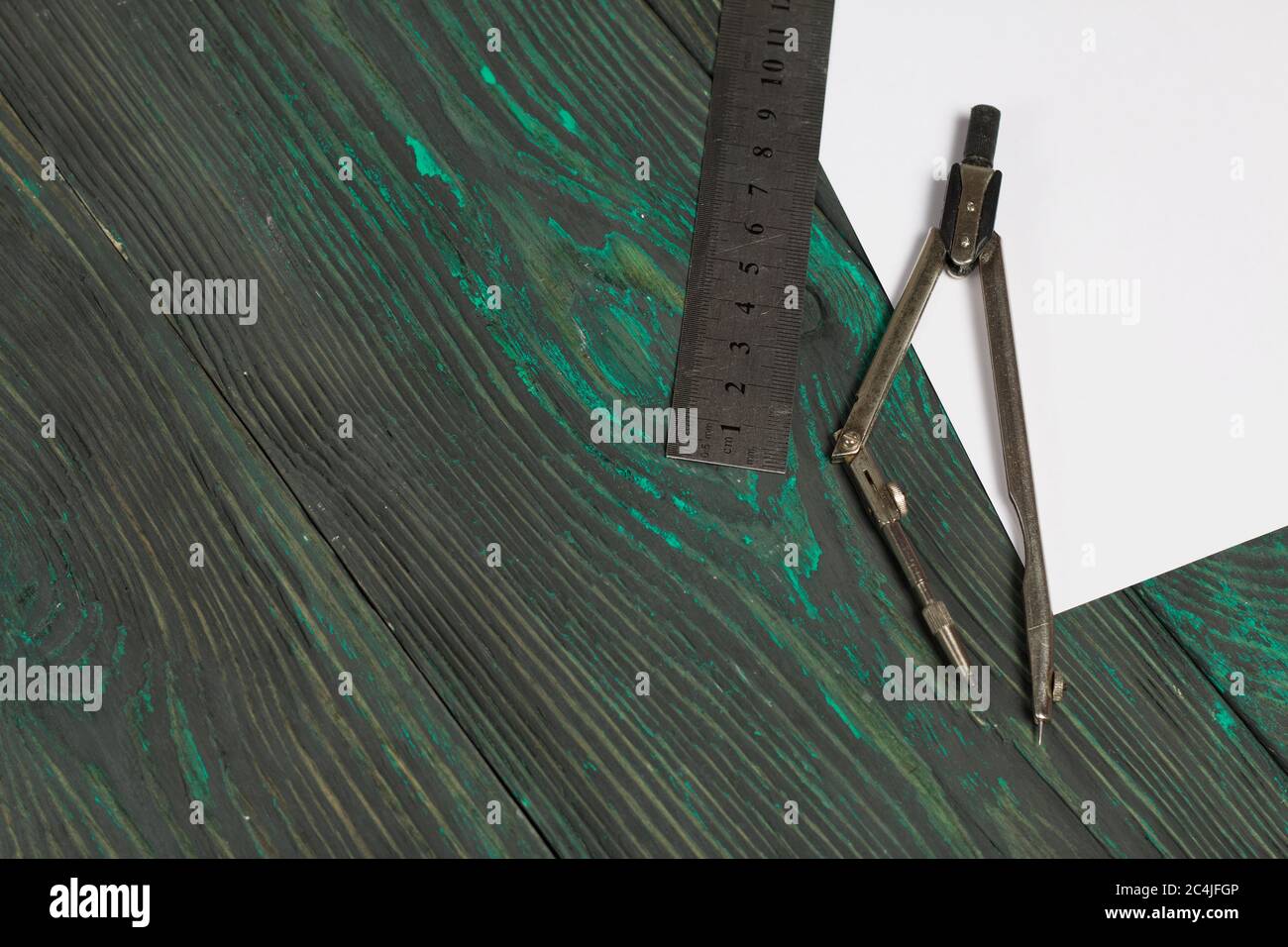 Set for drawing. Two compasses, a metal ruler and a sheet of white ...