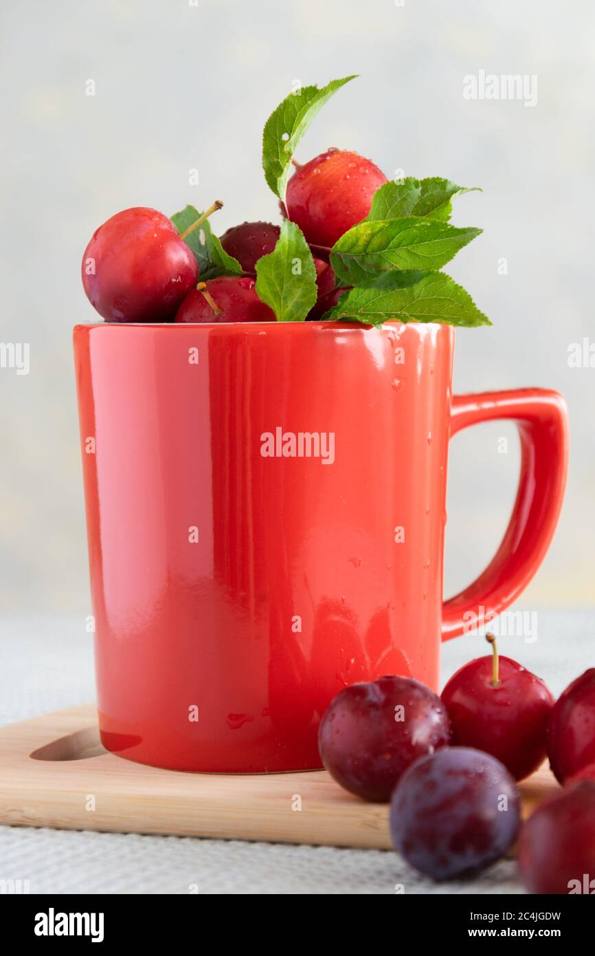 Fresh raw plums in red cup, healthy sweet food Stock Photo - Alamy