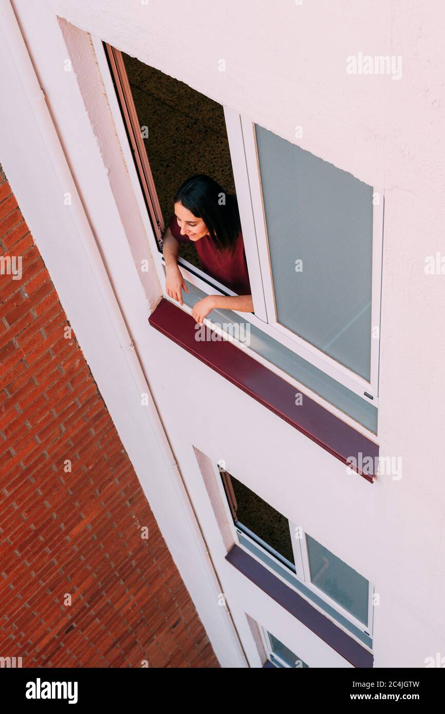 Woman looking through window building hi-res stock photography and ...