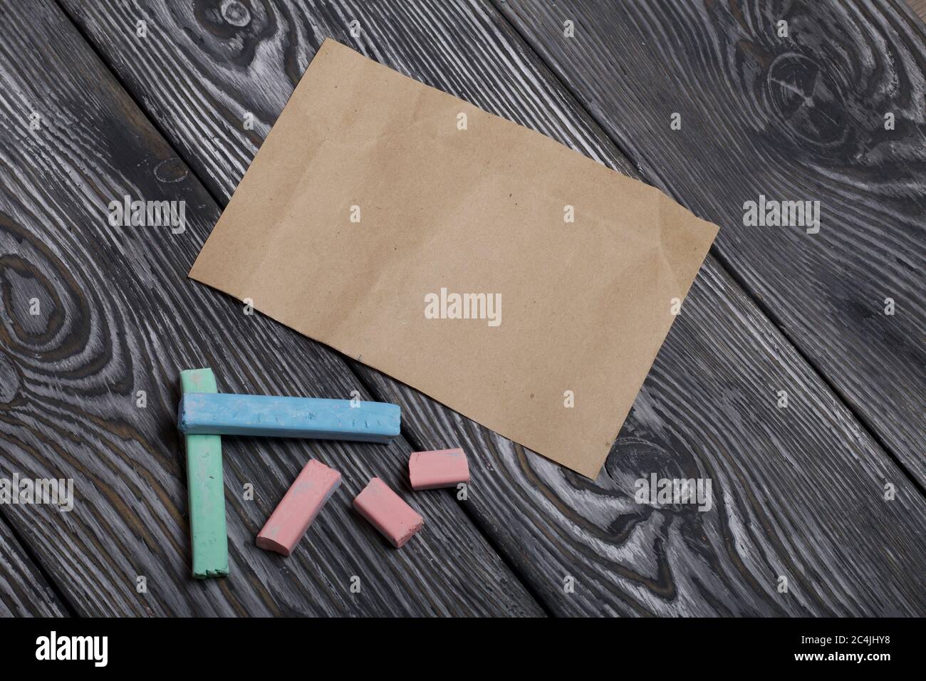 Pieces of chalk for drawing, different colors. Paper. They lie on pine ...