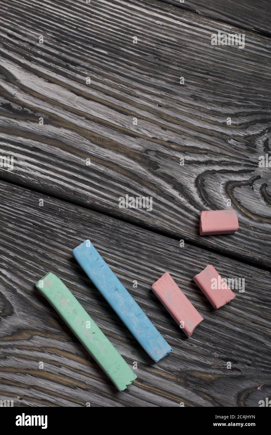 Pieces of chalk for drawing, different colors. They lie on pine boards ...