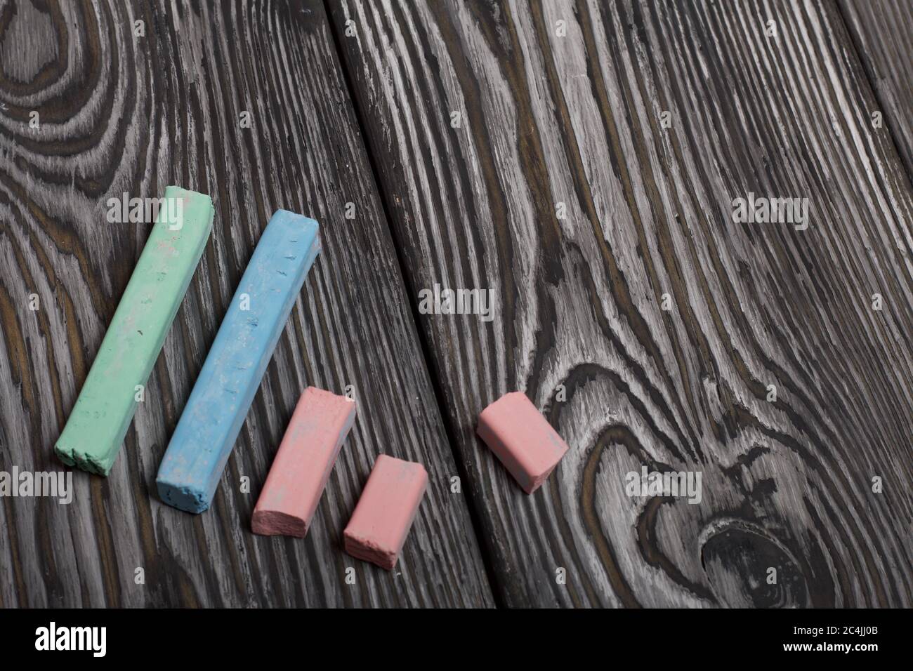 Pieces of chalk for drawing, different colors. They lie on pine boards ...
