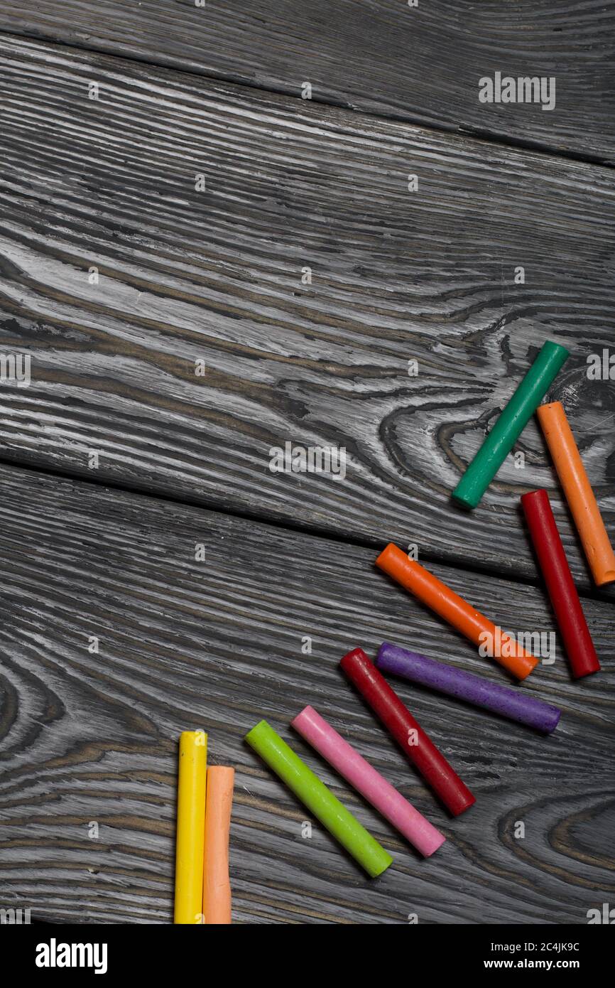 Pastel for drawing. Sticks of different colors. They lie on pine boards ...