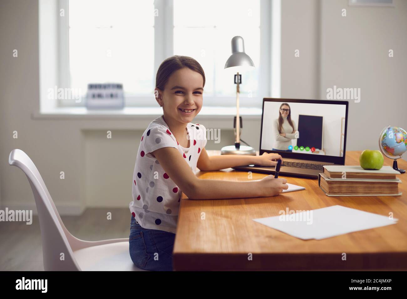 Online video call teaching a child. A little girl doing a lesson ...