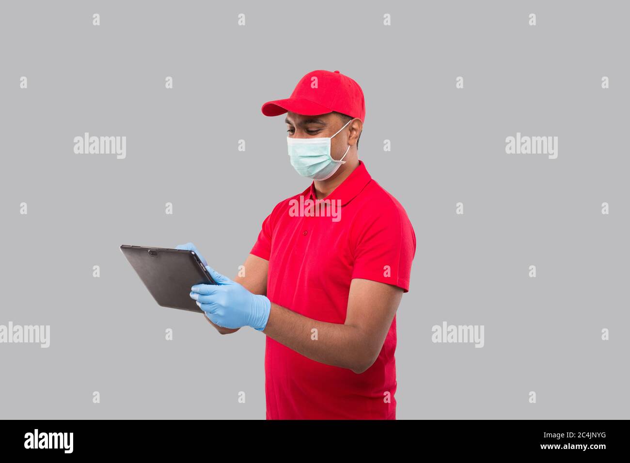 Delivery Man Using Tablet Wearing Medical Mask and Gloves. Indian ...