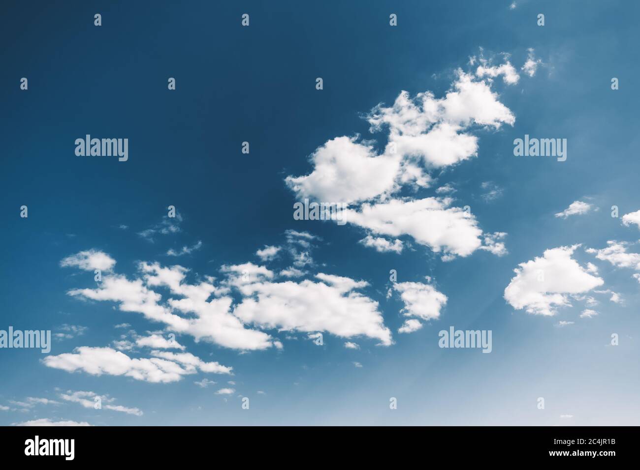 Blue sky with lush white clouds in the sun Stock Photo - Alamy