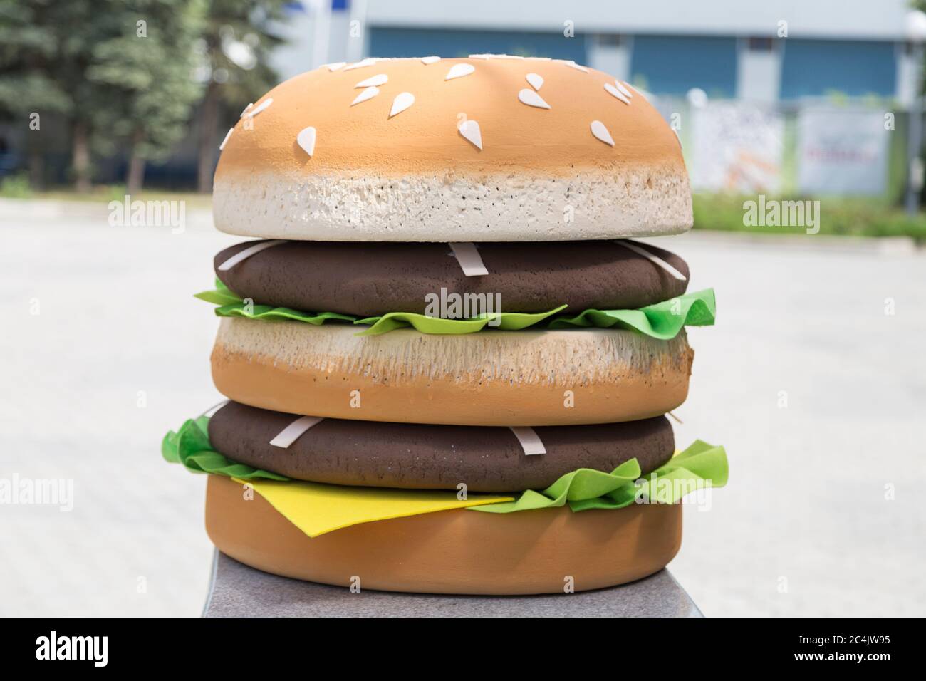 Big artificial burger is made with a love. It is located in the street ...