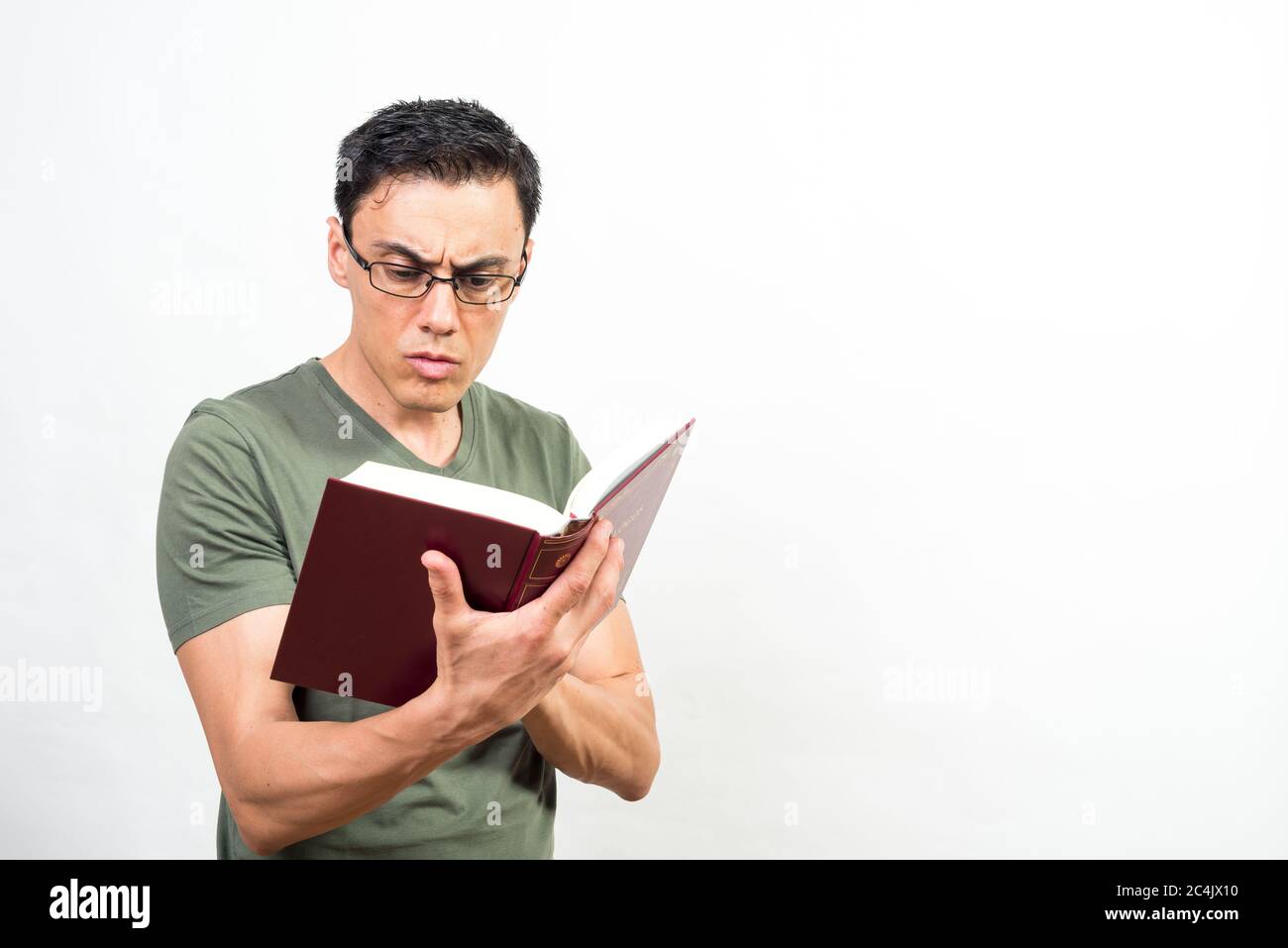 Man with glasses, very concentrated on reading a book. Mid shot. White ...