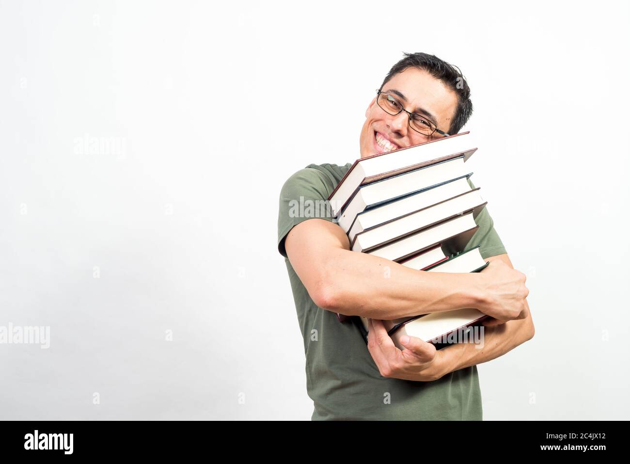 Man with glasses in love with reading hugging a pile of books. Mid shot ...