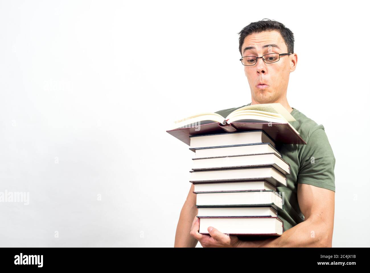 Concentrated man reading while holding a pile of books. Mid shot. White ...