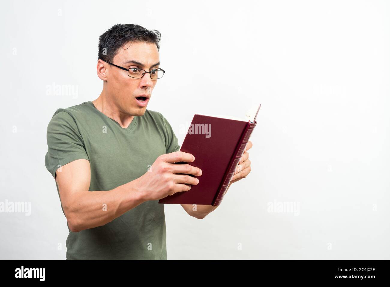 Man reading something that is surprising him a lot in a book. Mid shot ...