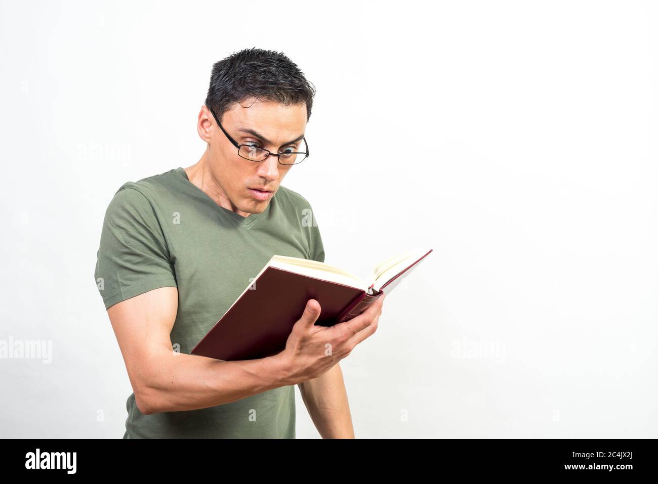 Man reading something that is surprising him a lot in a book. Mid shot ...