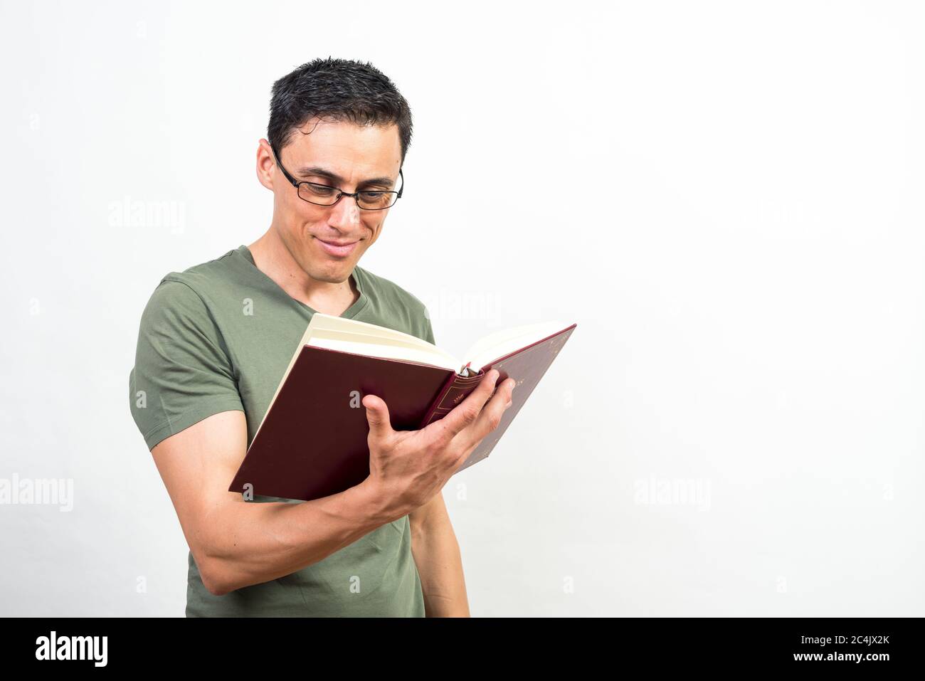 Smiling man with glasses reading a book. Mid shot. White background ...