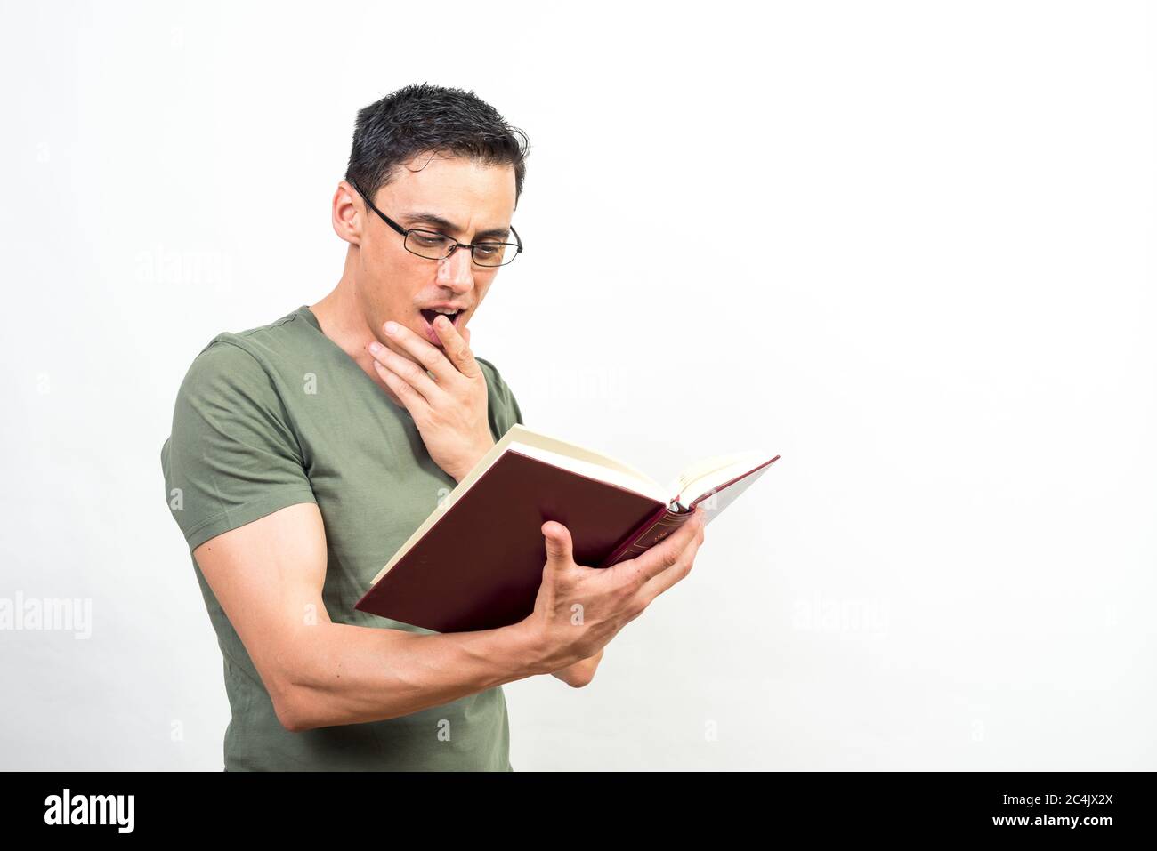 Man reading something that is surprising him a lot in a book. Mid shot ...