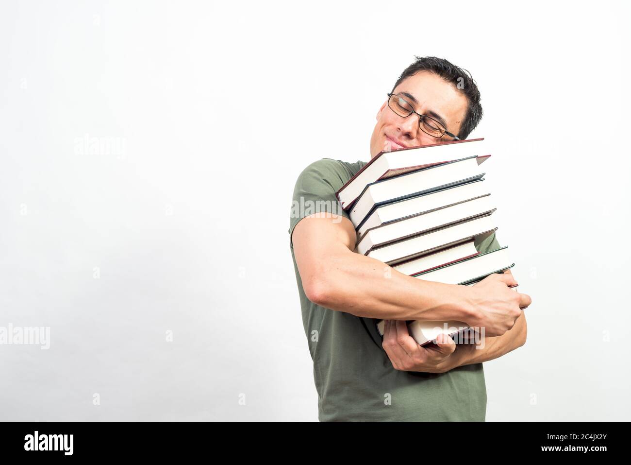 Man in love with reading hugging a pile of books. Mid shot. White ...