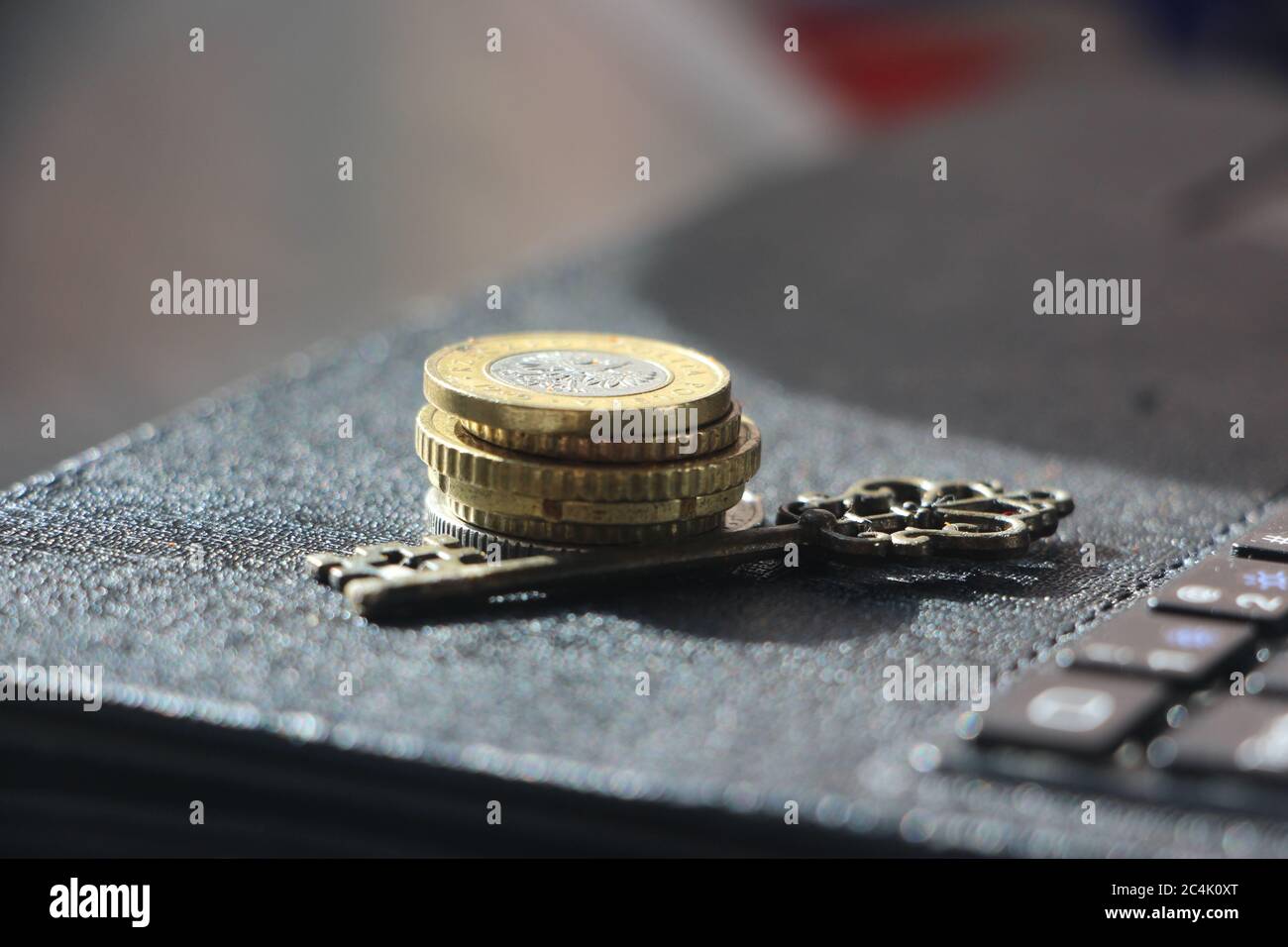 Old style rustic vintage key and stack of coins. Business startup or ...