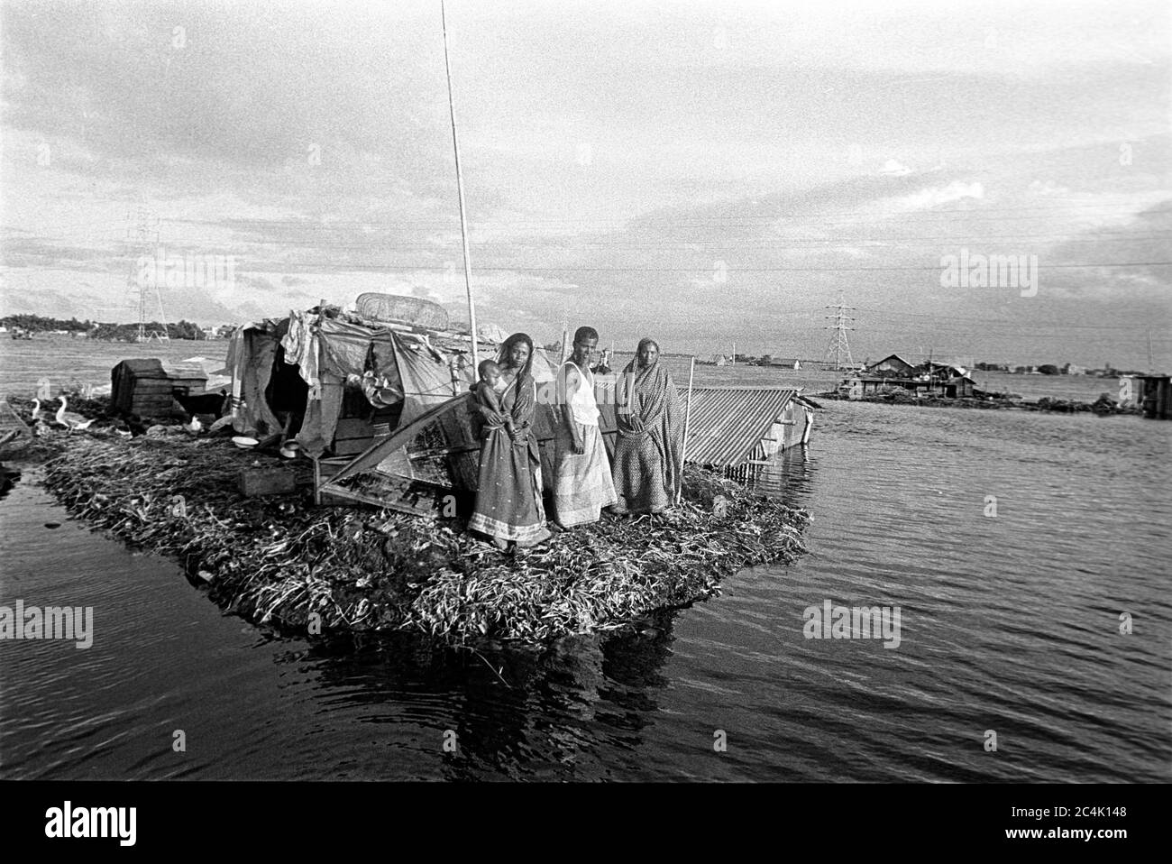 A family from flood affected area living on a raft made of water ...