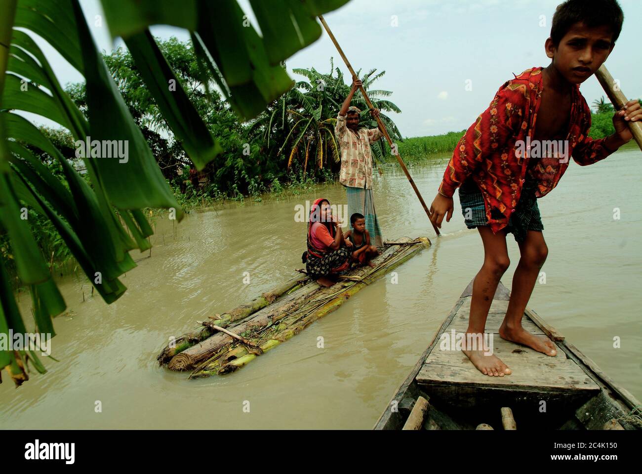 A woman with her son on a raft going to their house from the flood ...