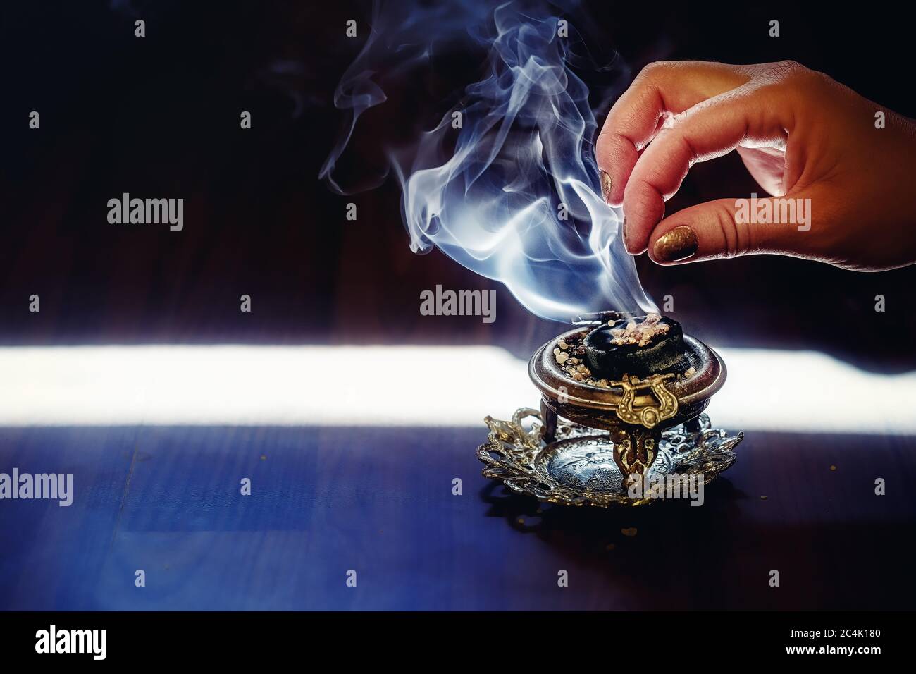 incense in a woman hand, incense smoke on a black background Stock ...