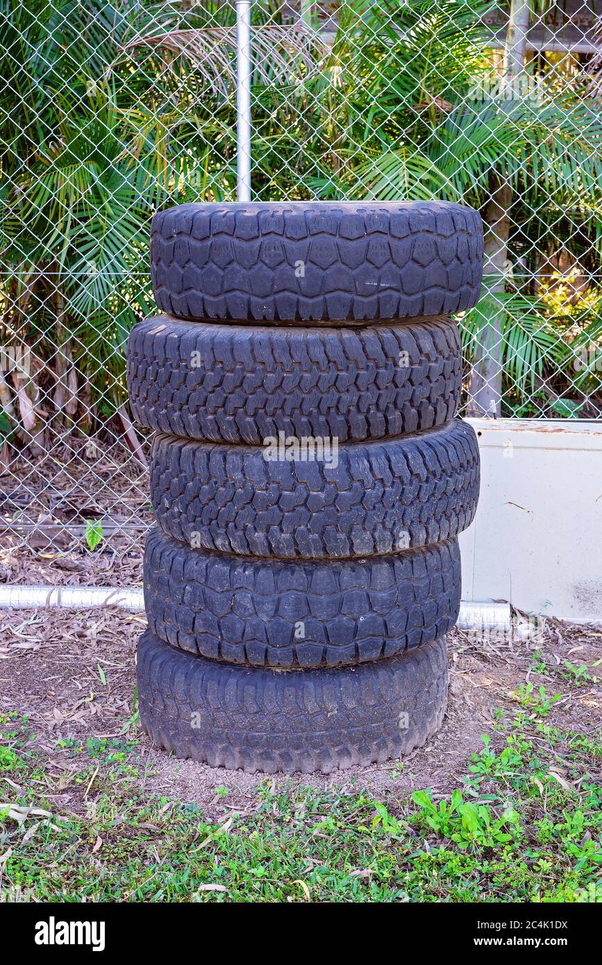 A stack of five car tyres against a wire fence Stock Photo - Alamy